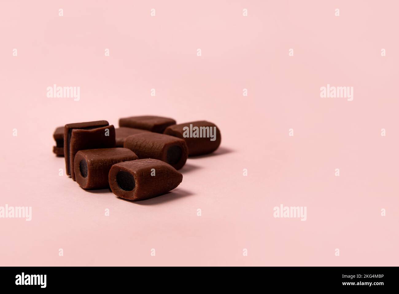 Chocolate licorice candies on pink background Stock Photo - Alamy