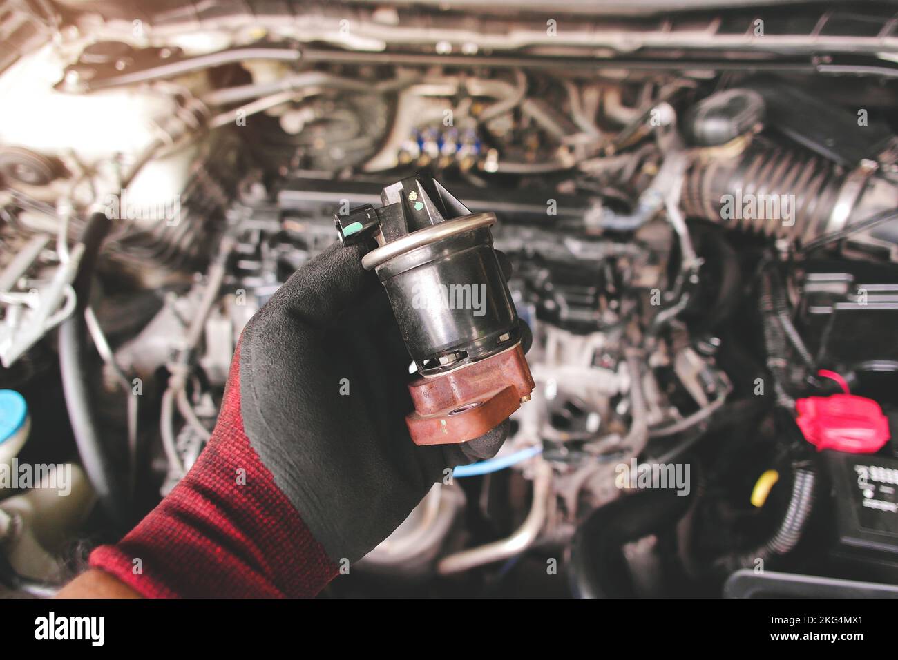 Close up of the EGR exhaust gas recirculation in the auto mechanic hand ...