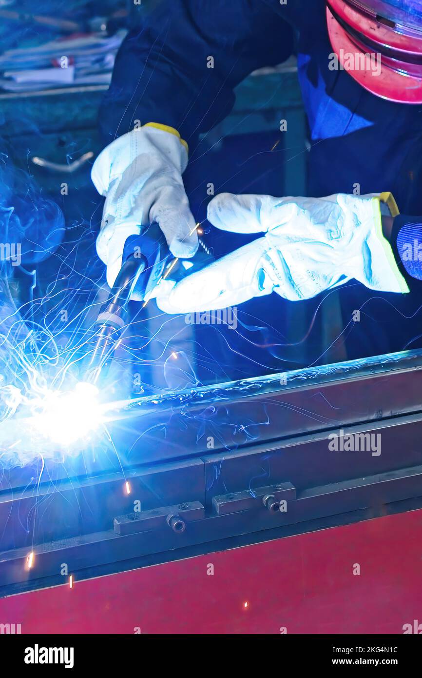 closeup portrait of a workman welding metal in fabrication workshop ...