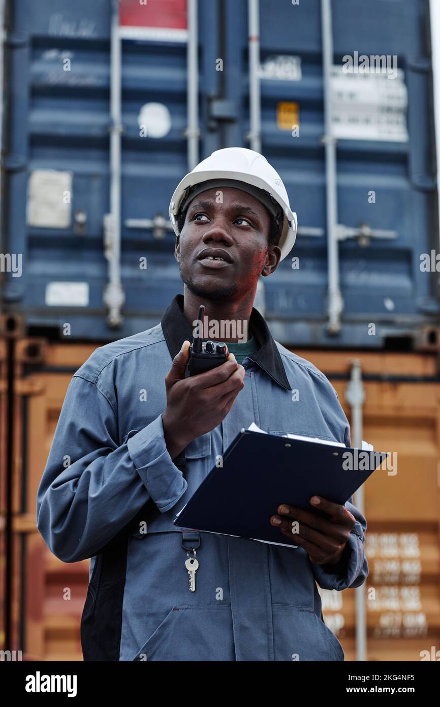 Vertical waist up portrait of black male worker wearing hardhat in ...