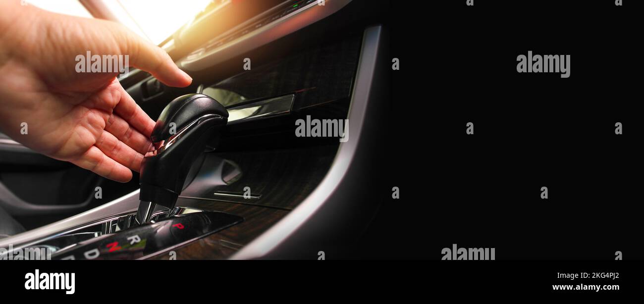 The driver hand is holding the gear lever to shift the automatic gear ...