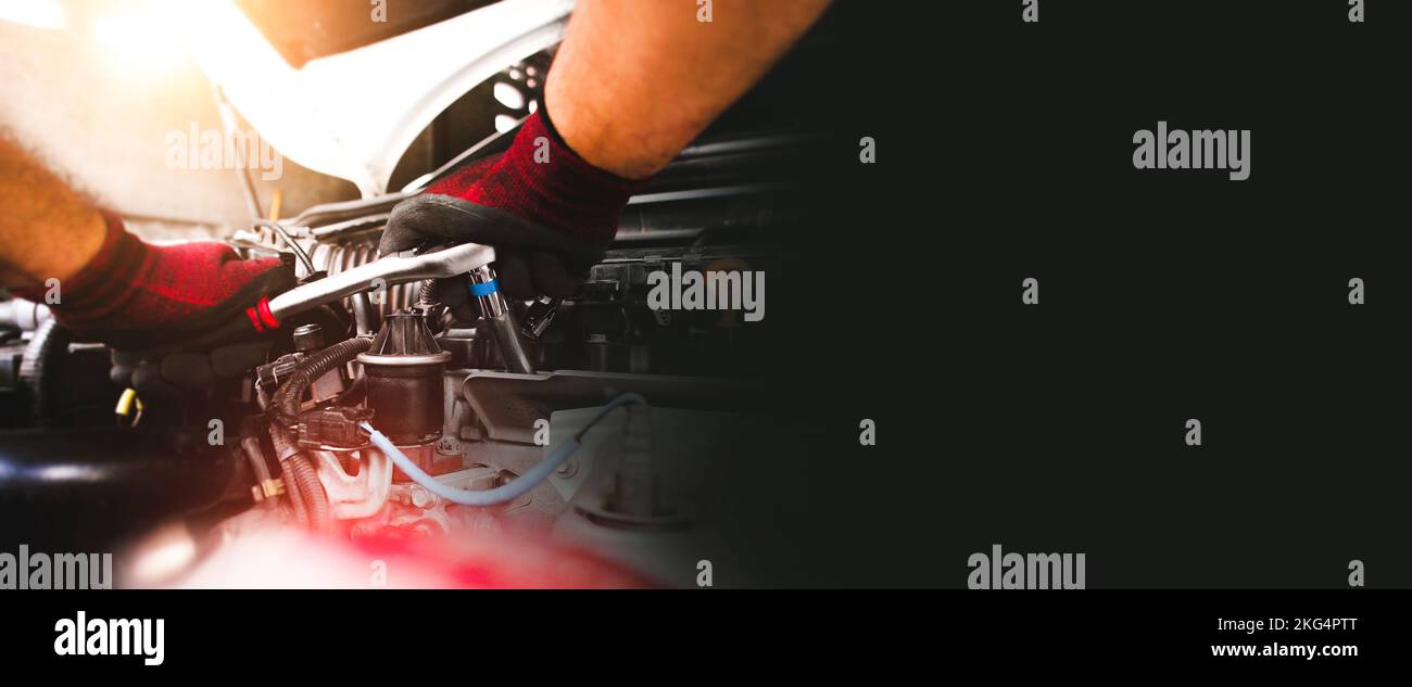 The red gloved hand of the auto mechanic is fastening the bolt with the ...