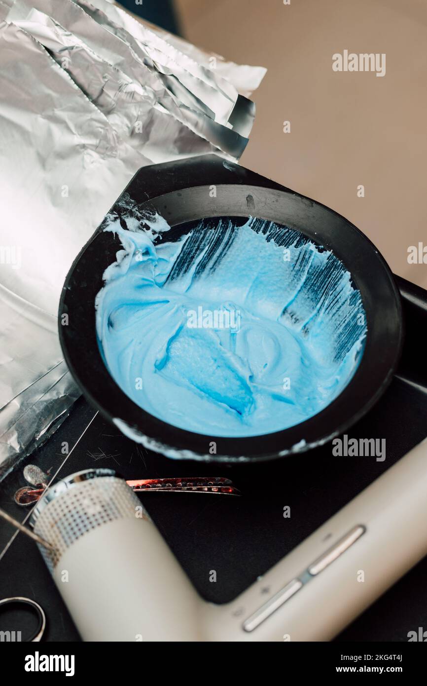 A professional hairdresser mixes a dye with an oxidizer. Hair coloring ...