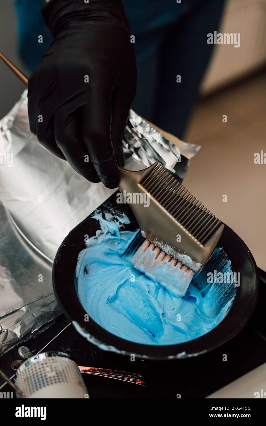 A professional hairdresser mixes a dye with an oxidizer. Hair coloring ...