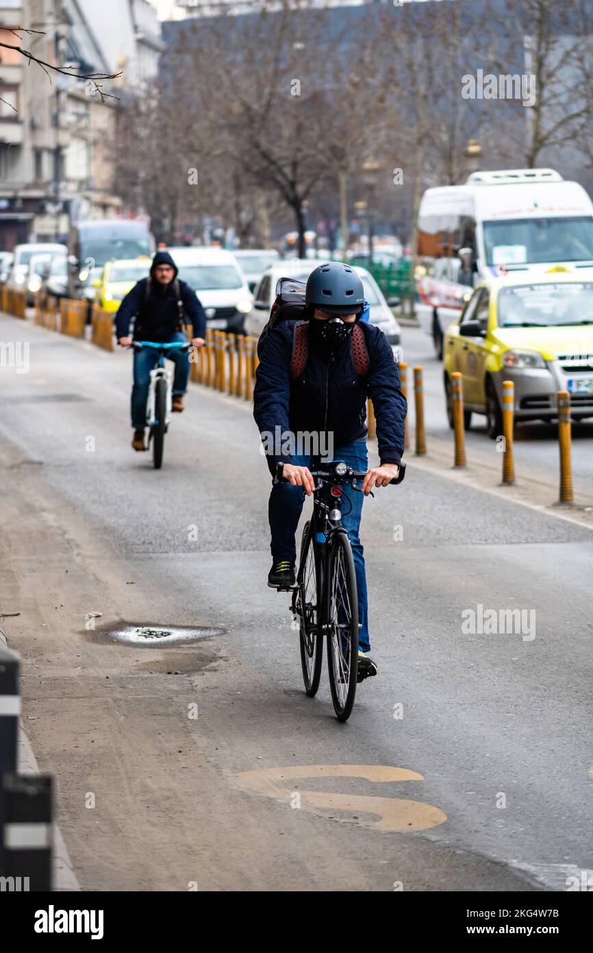 Riding a bicycle on the city streets. Commute to work in Bucharest ...
