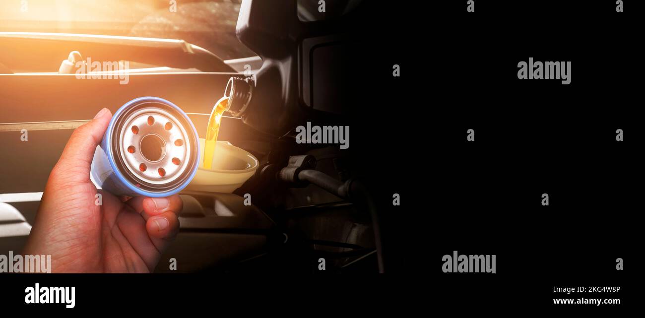 Mechanic hand showing oil filter against the background pouring motor ...