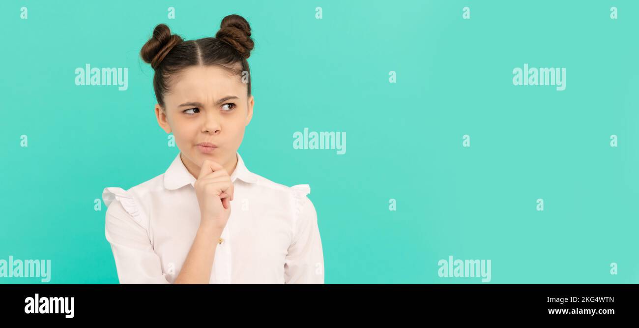 Thoughtful elementary school child think looking away blue background ...