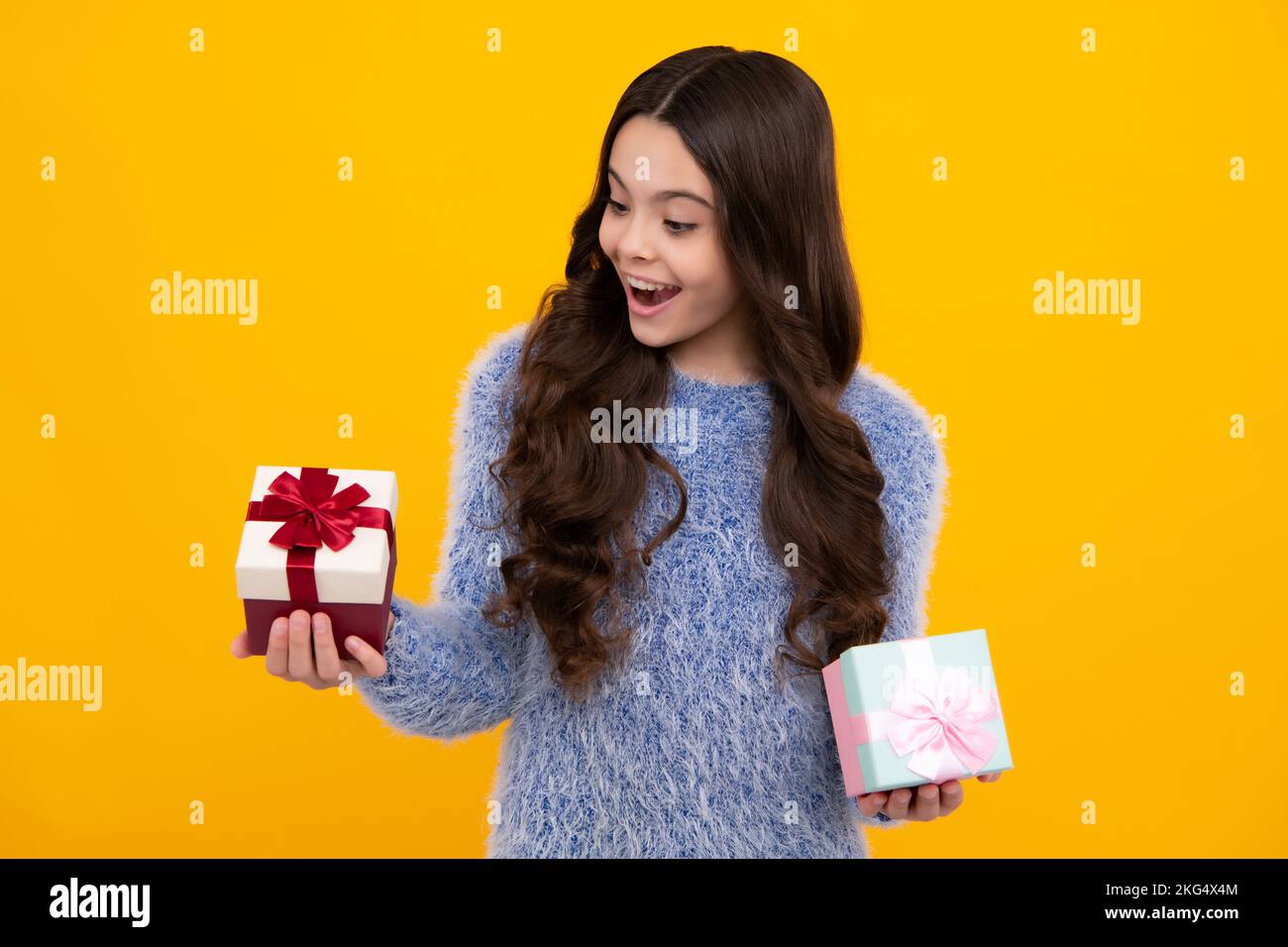 Amazed teenager. Child with gift present box on isolated studio ...