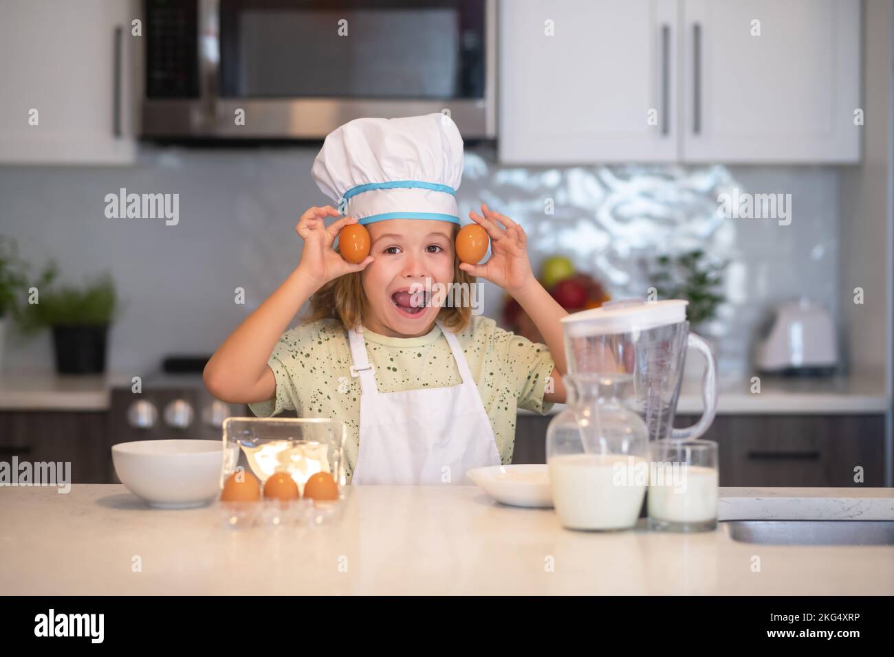 Child chef cook with eggs. Kid chef cook in chef hat preparing food on ...