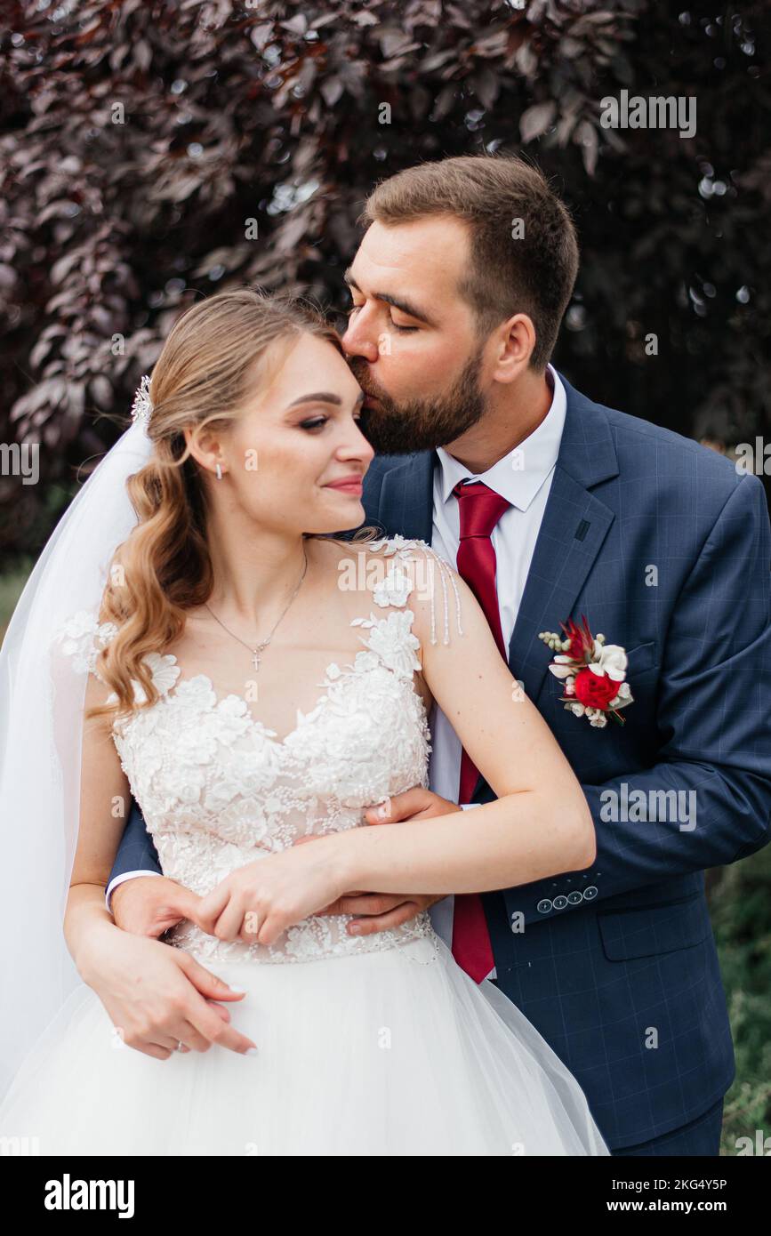 portrait of young bride and groom enjoying romantic moments outside ...