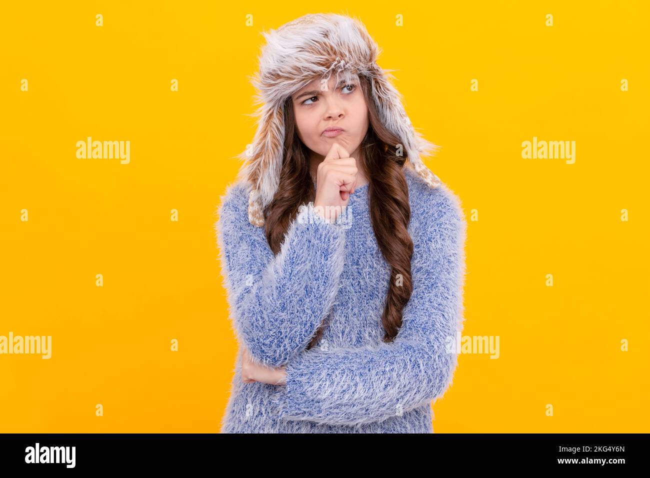 pondering kid long hair in hat on yellow background, childhood Stock ...