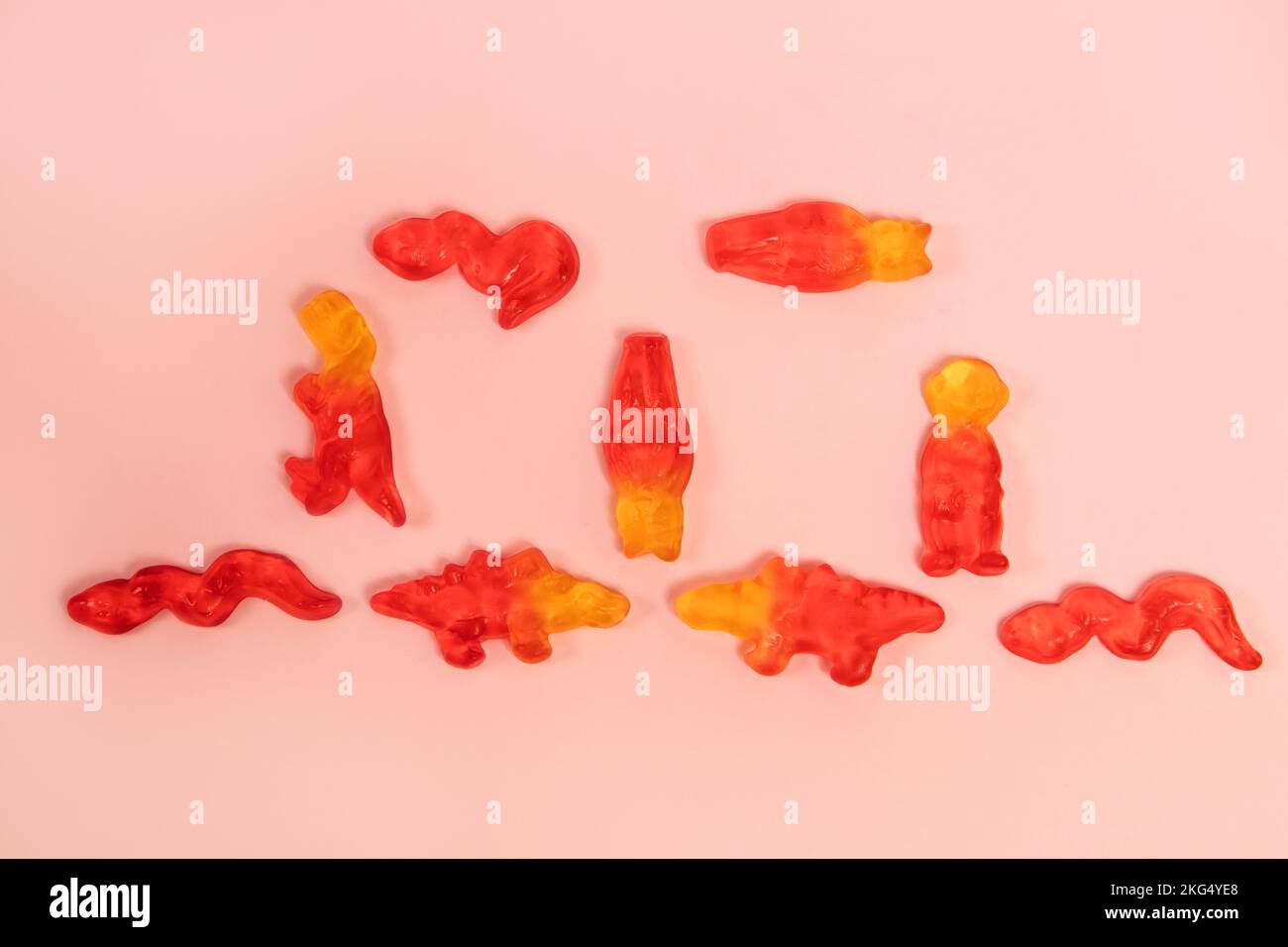 Yellow and red gummy candies on pink background Stock Photo - Alamy