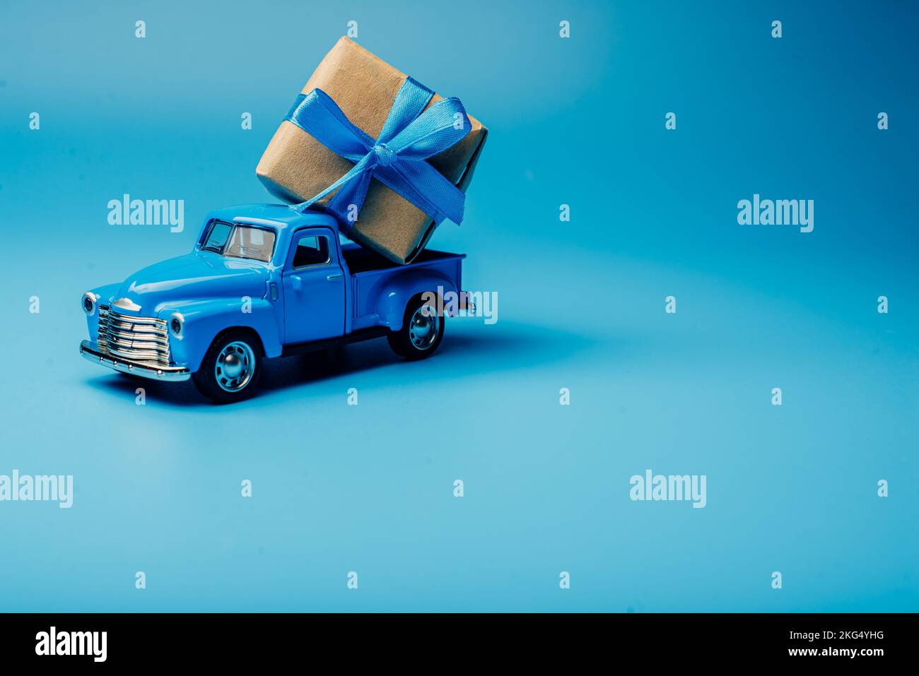 The toy car is loaded with a gift. minimalism in blue Stock Photo - Alamy