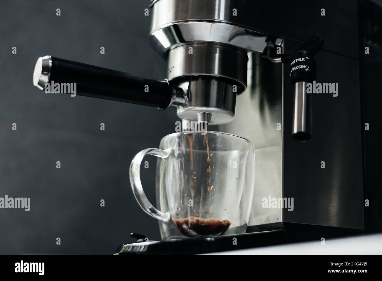 Coffee machine filling a cup with expresso. Transparent mug in ...