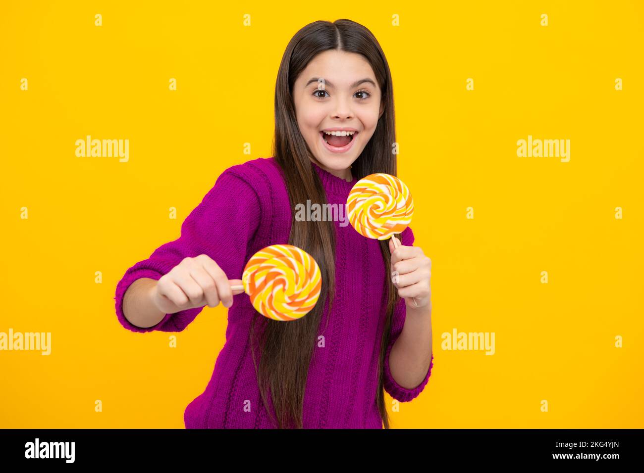 Excited face. Teenager girl with caramel candies on sticks, sweet sugar ...