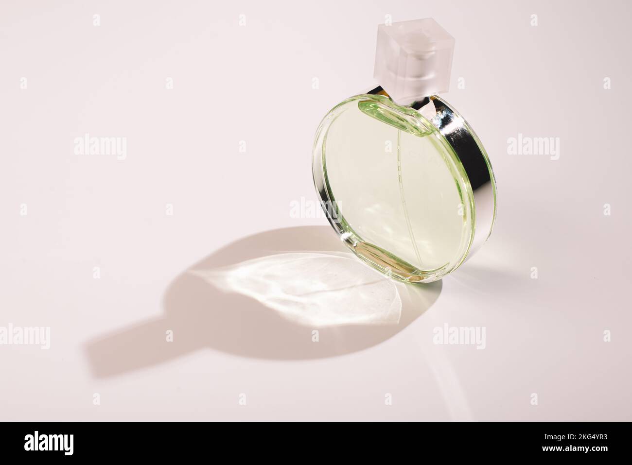 A bottle of perfume on a white background with a shadow Stock Photo - Alamy