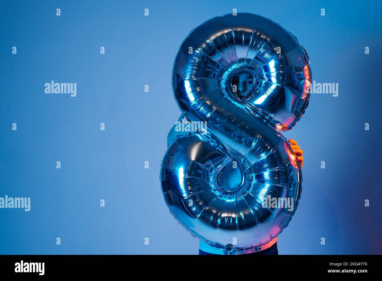 Inflatable ball eight in neon light holds a boy Stock Photo - Alamy