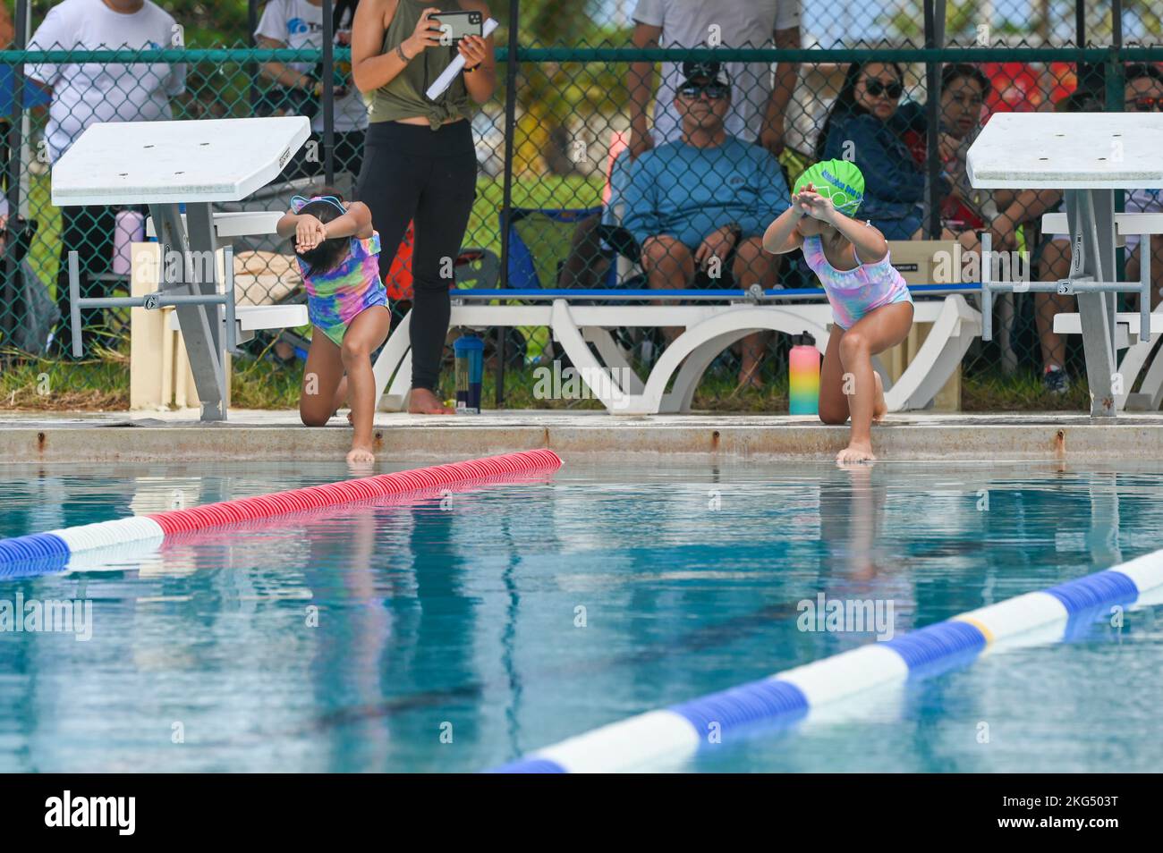 Two swimmers prepare to dive into a pool during a Guam Swimming ...