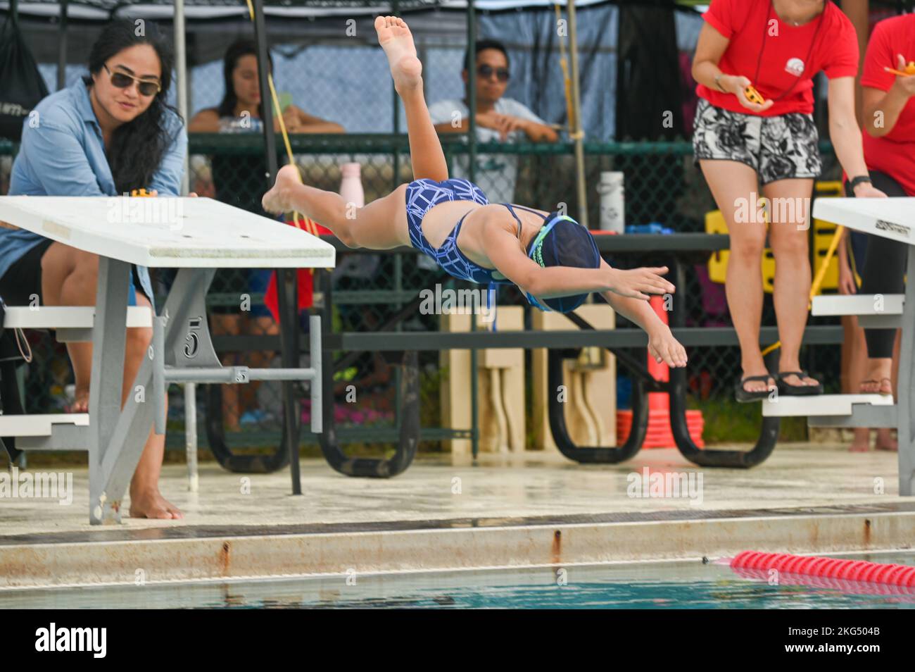A swimmer dives into a pool during a Guam Swimming Federation swim meet ...