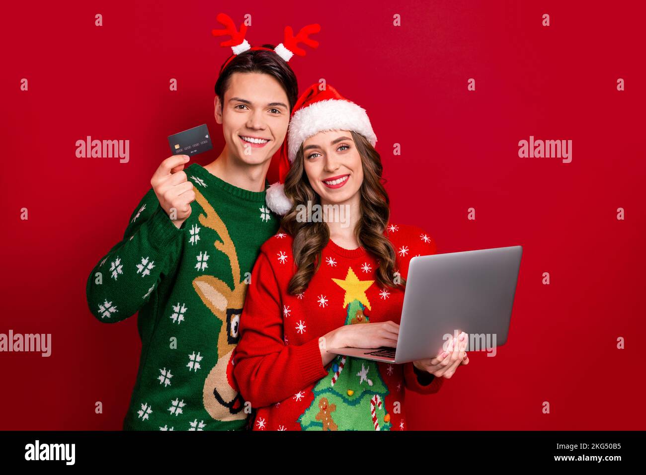 Photo Of Two Positive People Hold Debit Plastic Card Use Wireless Netbook Isolated On Red Color 