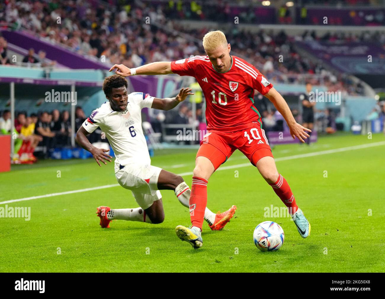 USA's Yunus Musah (left) and Wales' Aaron Ramsey battle for the ball ...