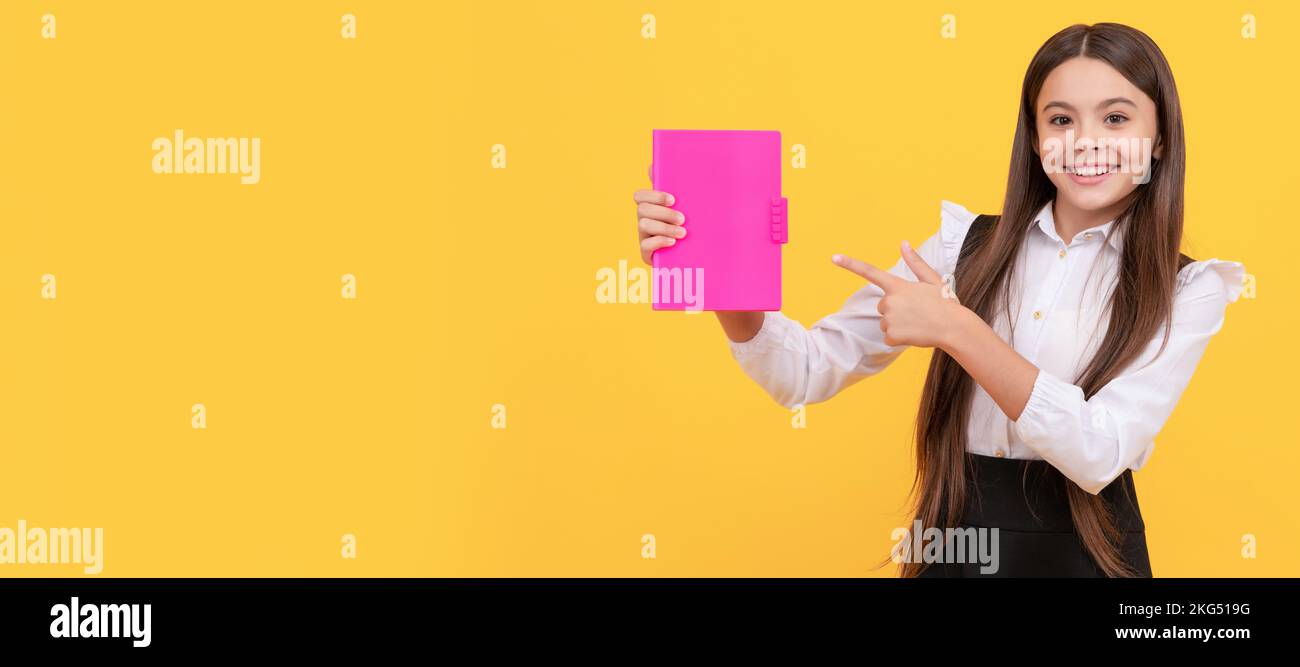 happy teen girl in school uniform pointing finger on book, advertising ...
