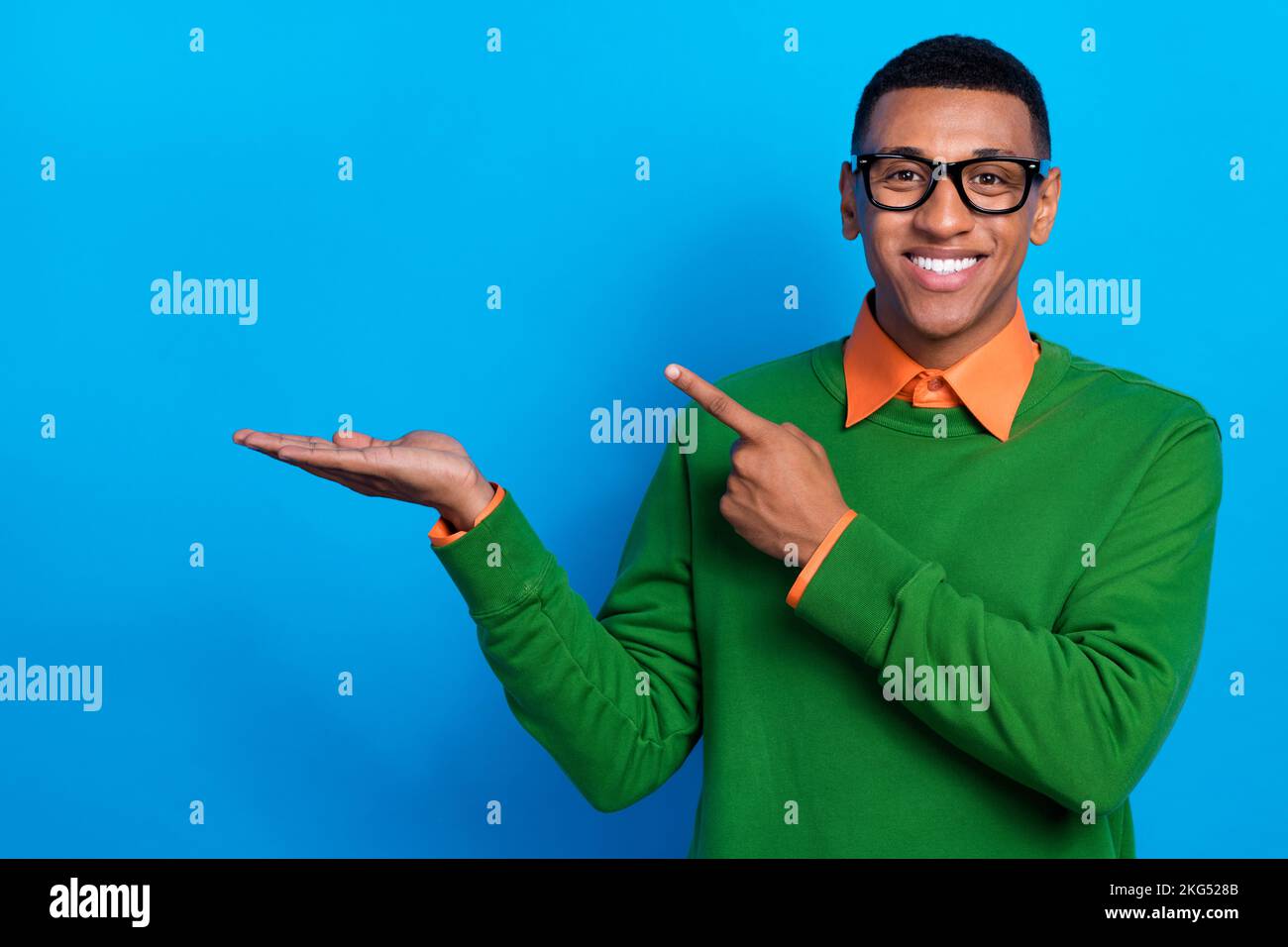 Portrait of satisfied guy wear orange shirt under green pullover ...