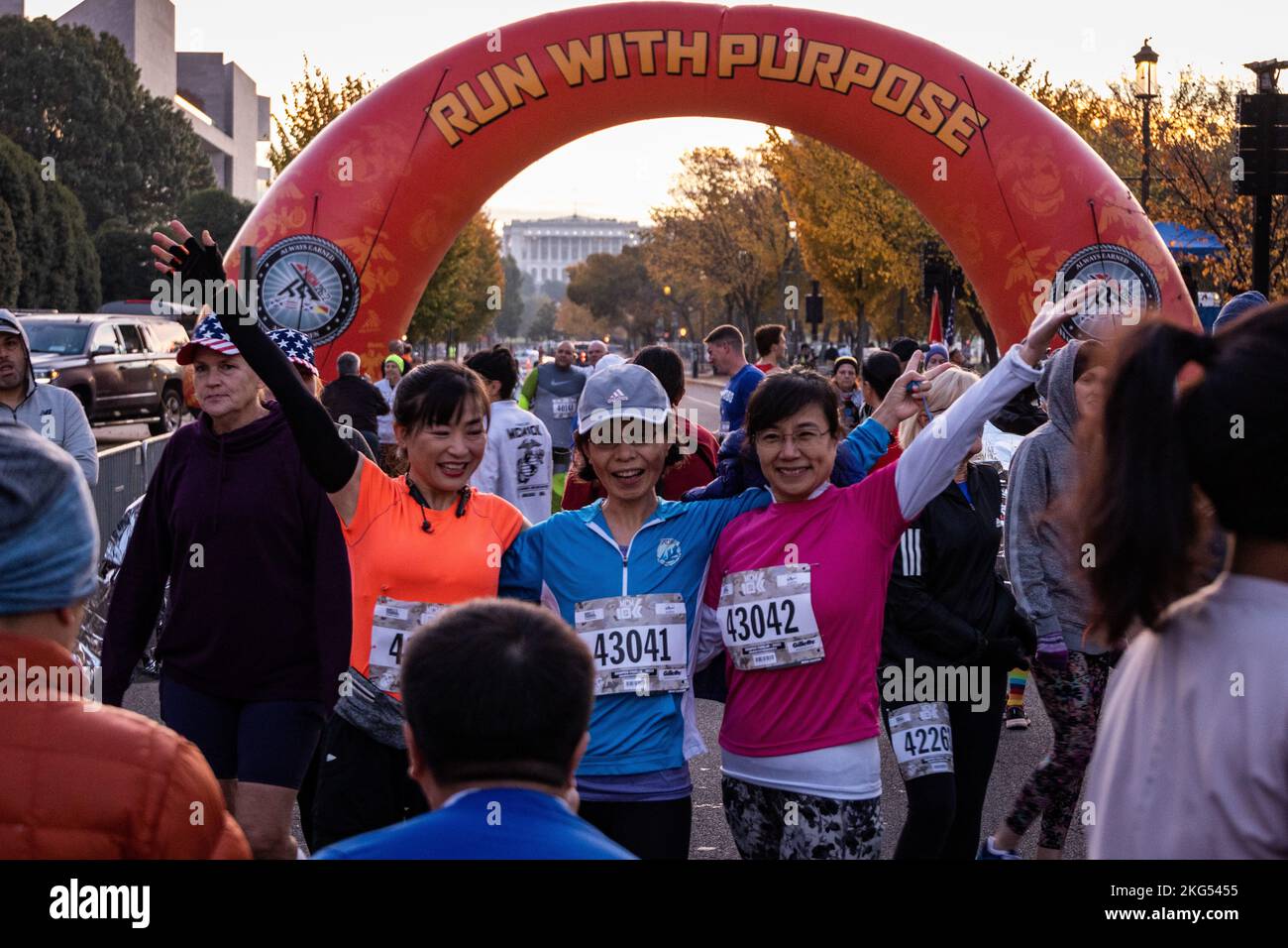Race participants take photos in front of the Marine Corps Marathon 10K ...