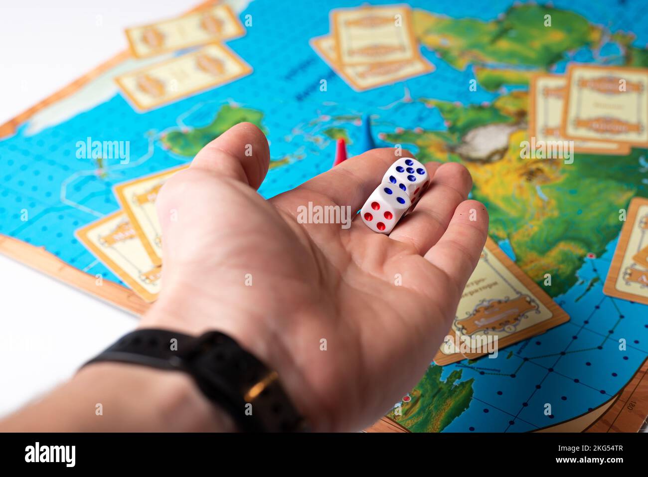 Hand throwing dice with numbers on the board game Stock Photo - Alamy