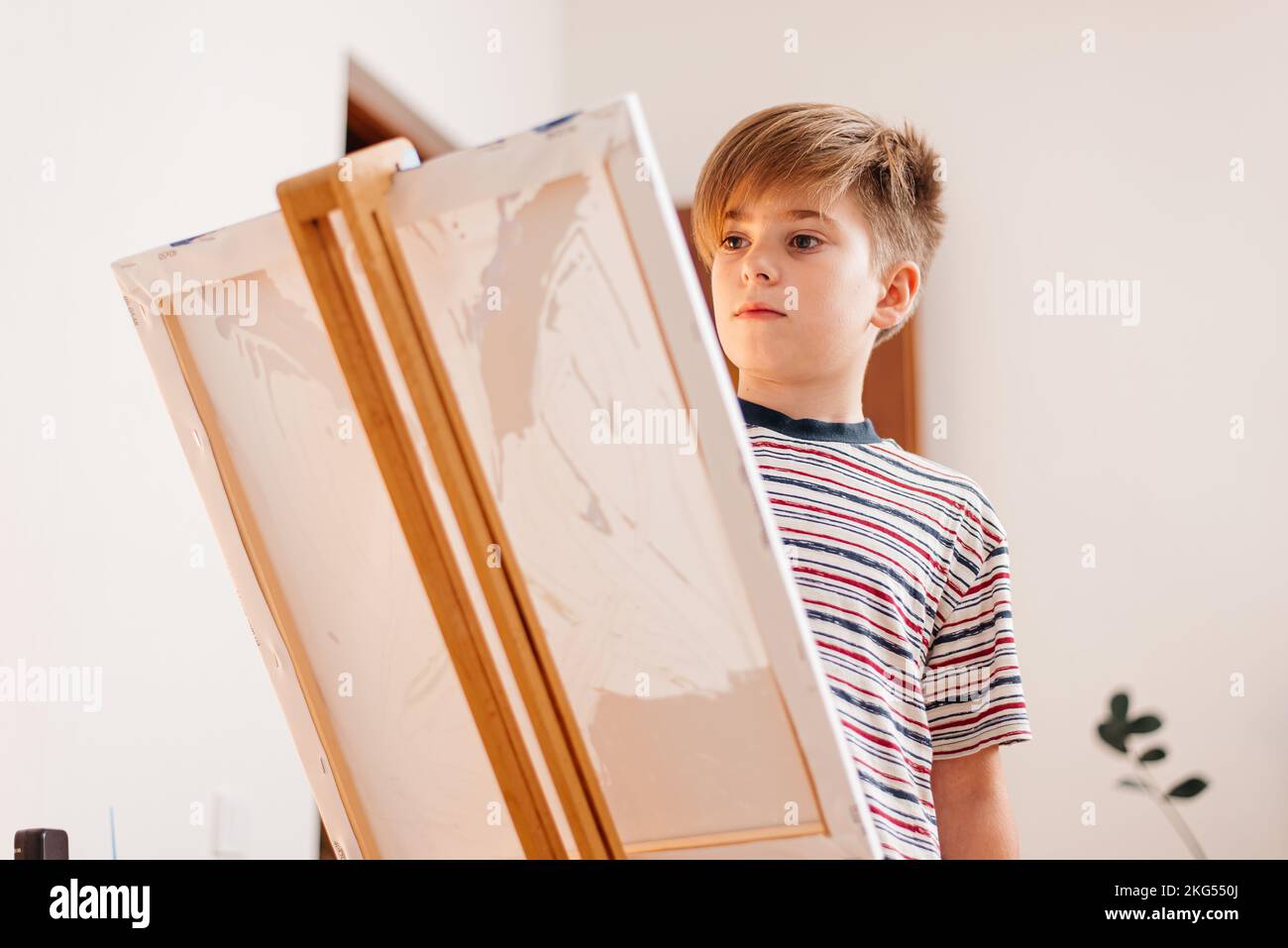 A boy draws a picture with paints and a brush color Stock Photo - Alamy