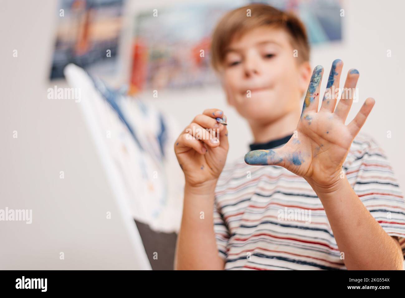 Brush with paints in the hands of a boy while drawing Stock Photo - Alamy