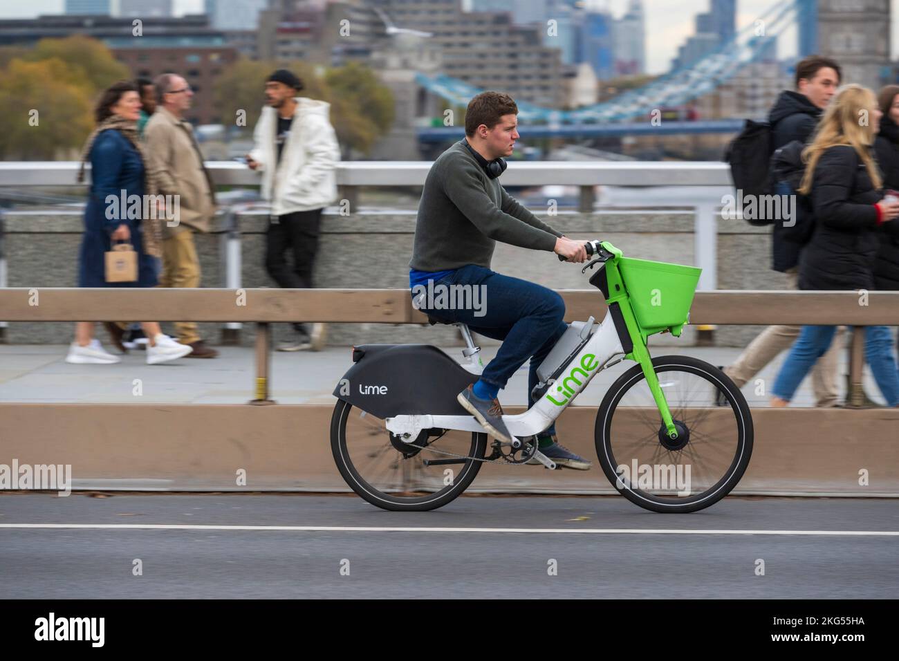 A man commuting on a Lime electric hire bike across London Bridge ...