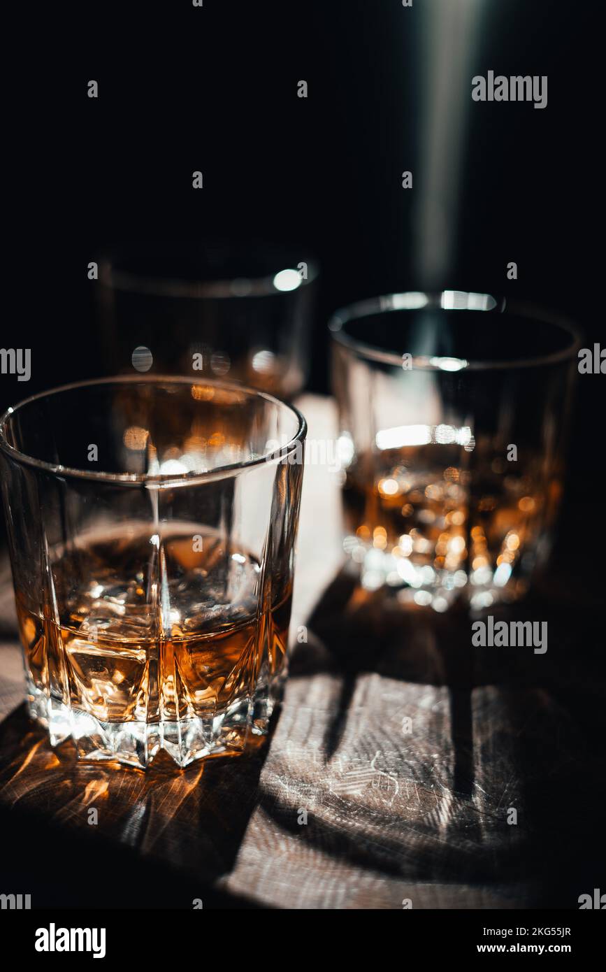 Whiskey with ice in glasses, rustic wood background, copy space Stock ...
