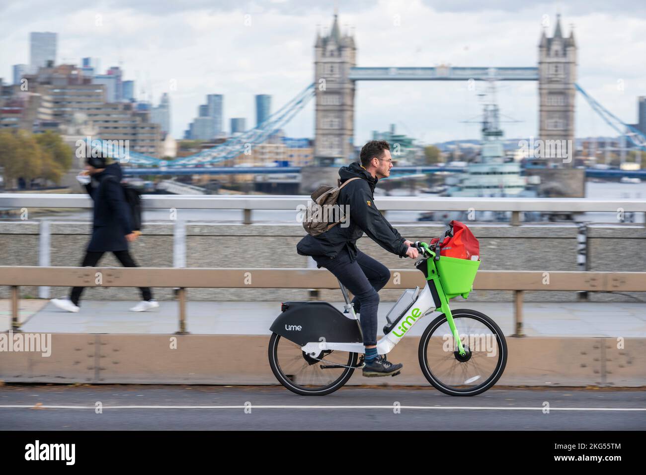 A man commuting on a Lime electric hire bike across London Bridge ...