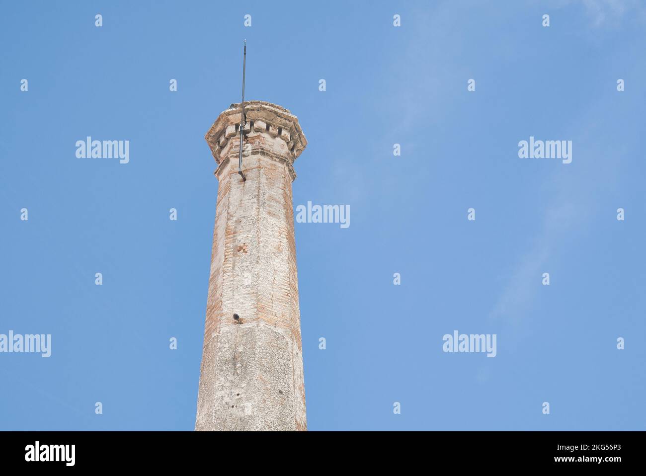 A low angle shot of the old tower of the Islamic mosque under the blue ...