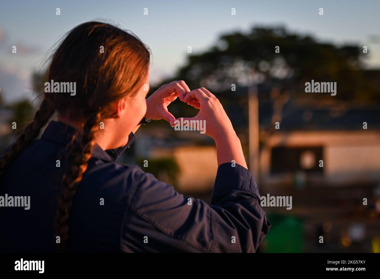 Ensign Haylee Lewis forms her hands into a heart and signals to her ...