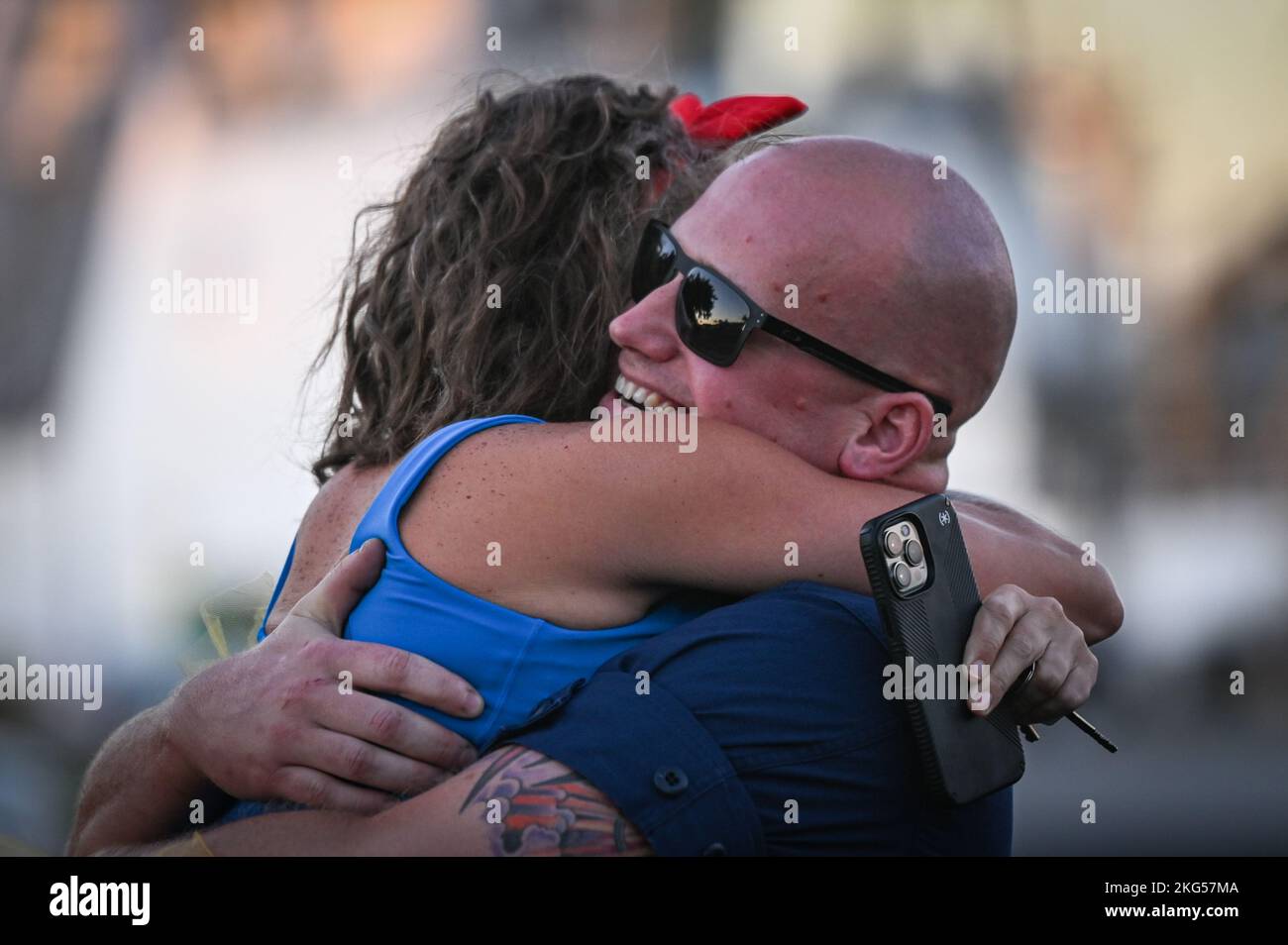 Petty Officer 1st Class Kyle Buell embraces his wife on the pier at ...