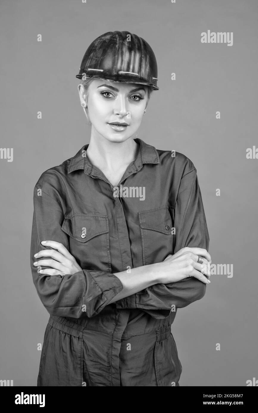 Woman Builder In Protective Helmet And Boilersuit On Orange Background