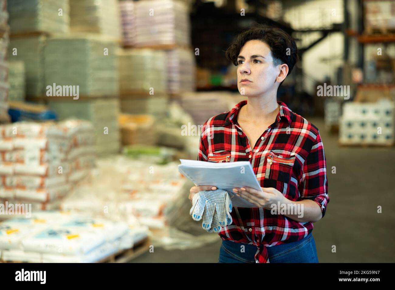 Woman checking documentation in warehouse Stock Photo - Alamy