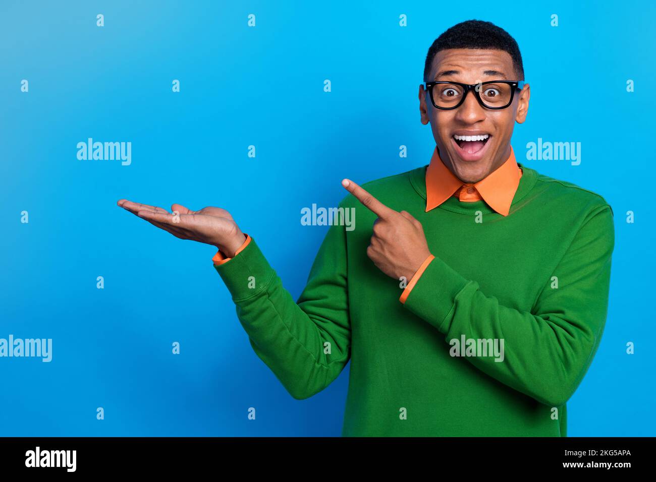 Portrait of ecstatic impressed guy orange shirt under green pullover ...