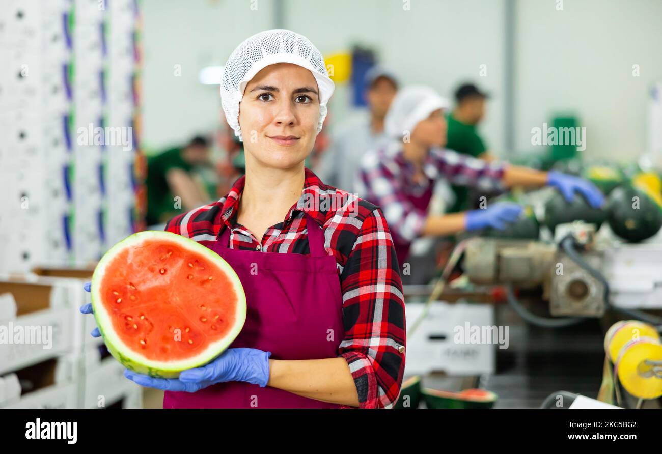 Portrait of positive woman fruit factory worker with watermelon Stock ...