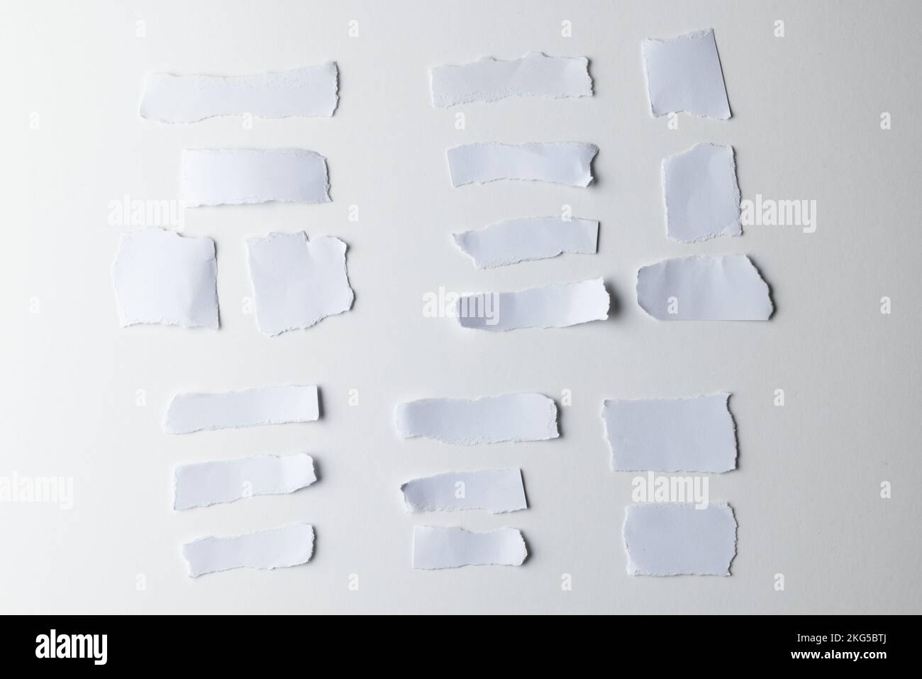 Ripped up pieces of white paper with copy space on white background ...