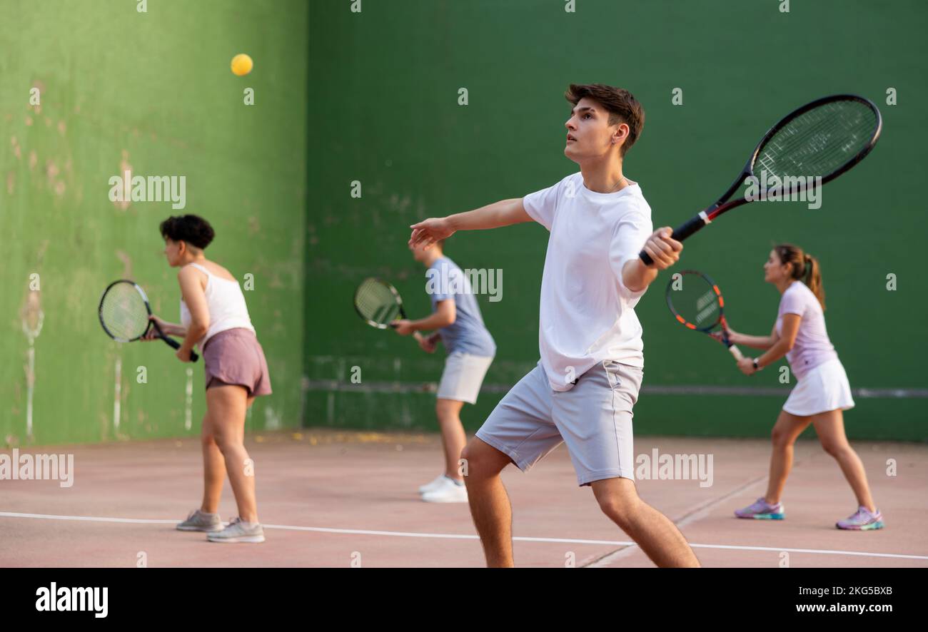 Young male pelota player hitting ball with racket Stock Photo - Alamy