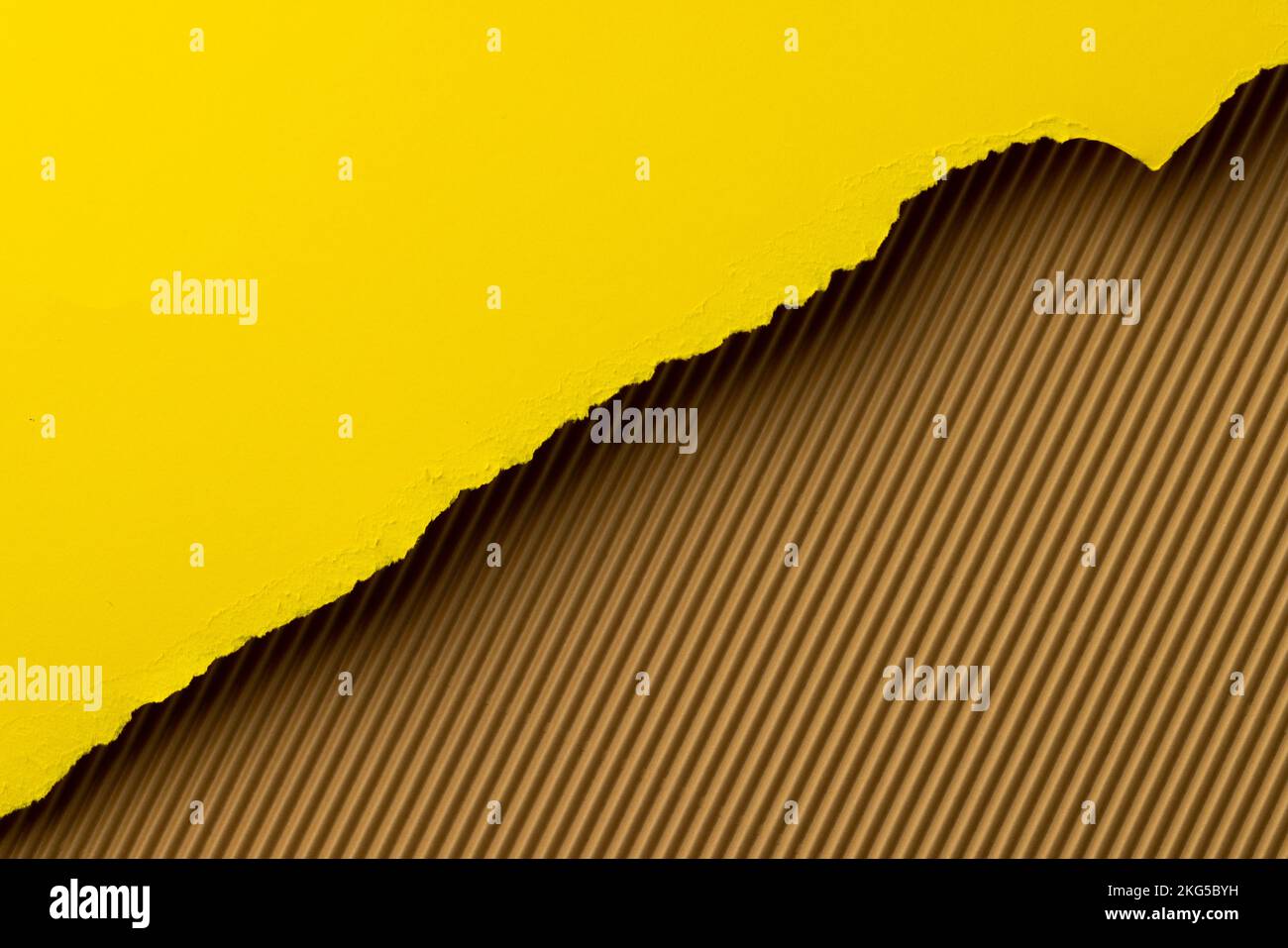 Ripped up pieces of yellow paper with copy space on cardboard ...