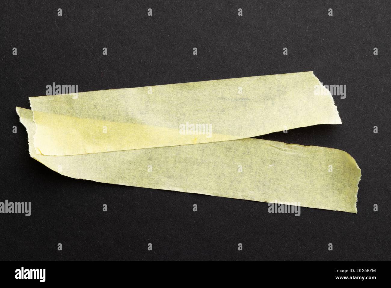 Ripped up pieces of masking tape with copy space on black background ...