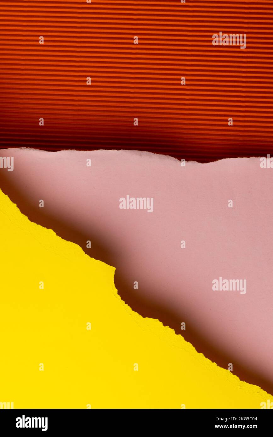 Ripped up pieces of coloured paper with copy space on cardboard ...