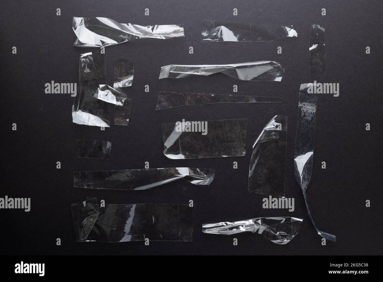 Ripped up pieces of transparent tape on black background Stock Photo ...
