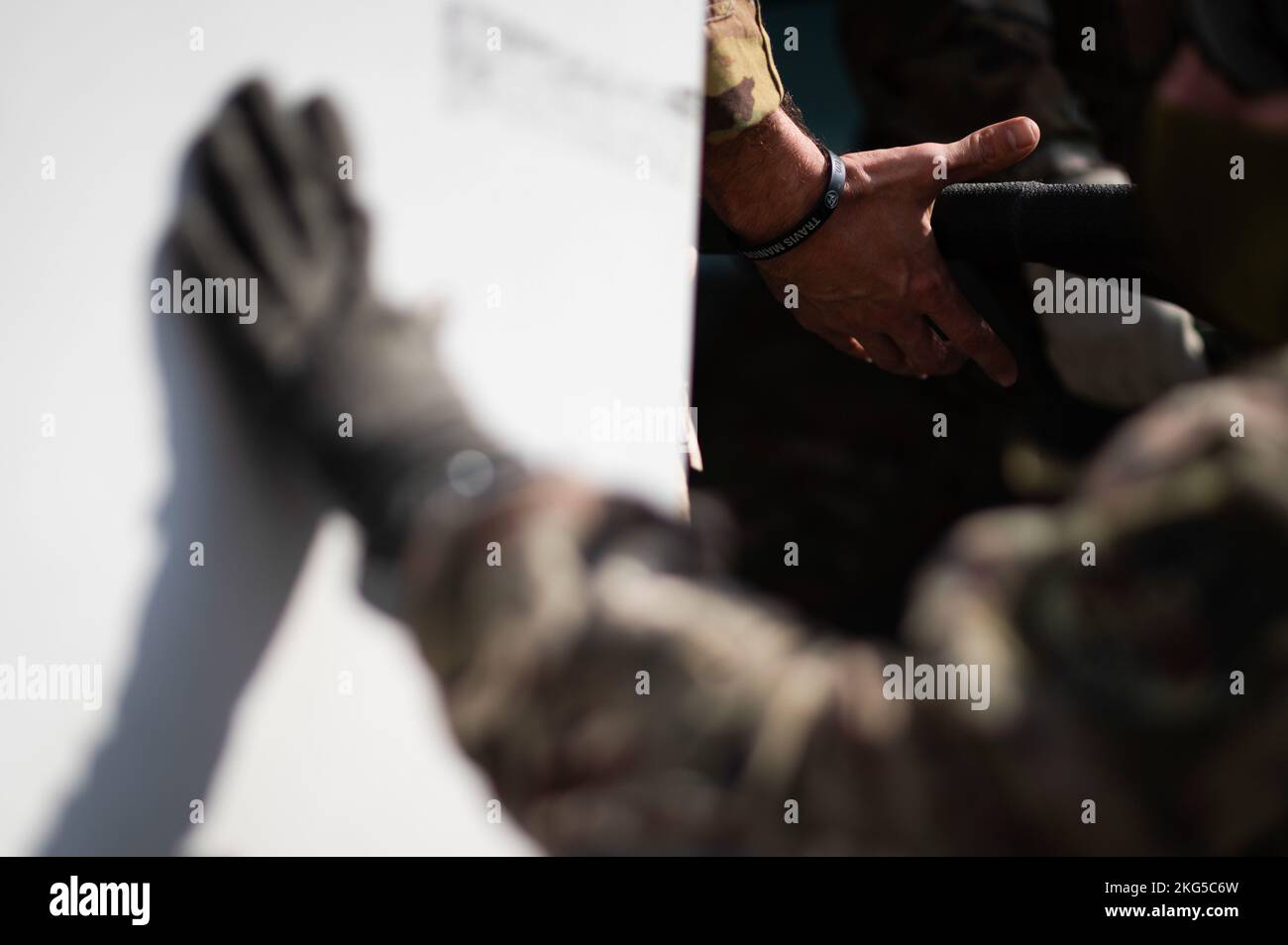 An Airmen grabs a simulated patient litter to transfer onto the ambus ...