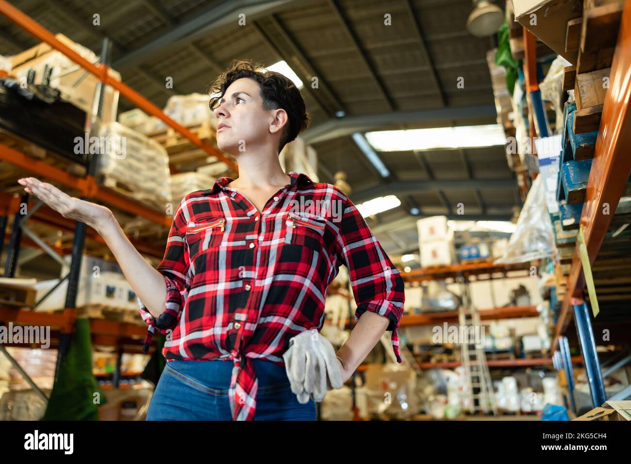 Thoughtful female storekeeper looking for tedious goods in building ...