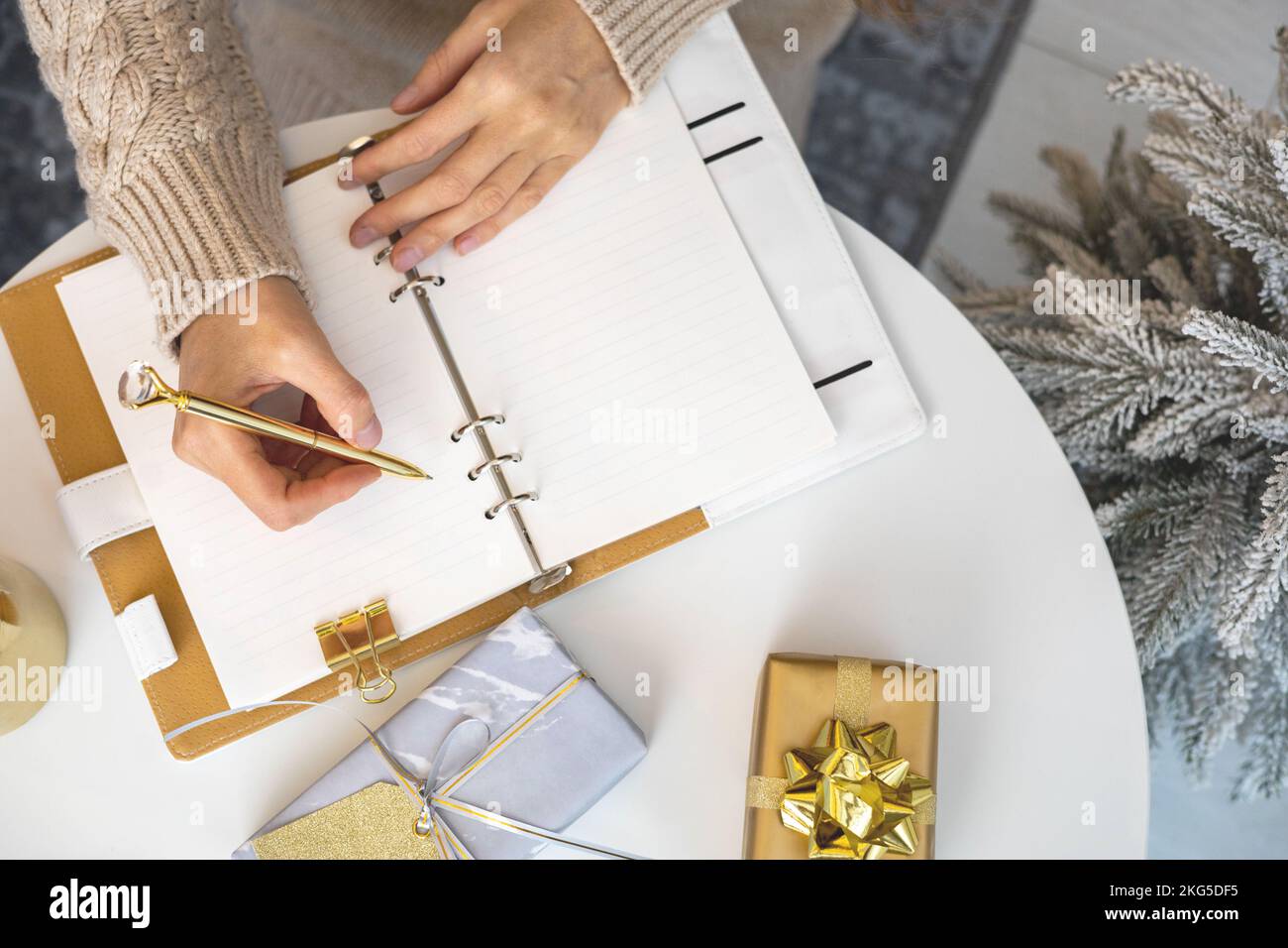 Happy young woman writing wish list dream notes for Christmas holiday ...